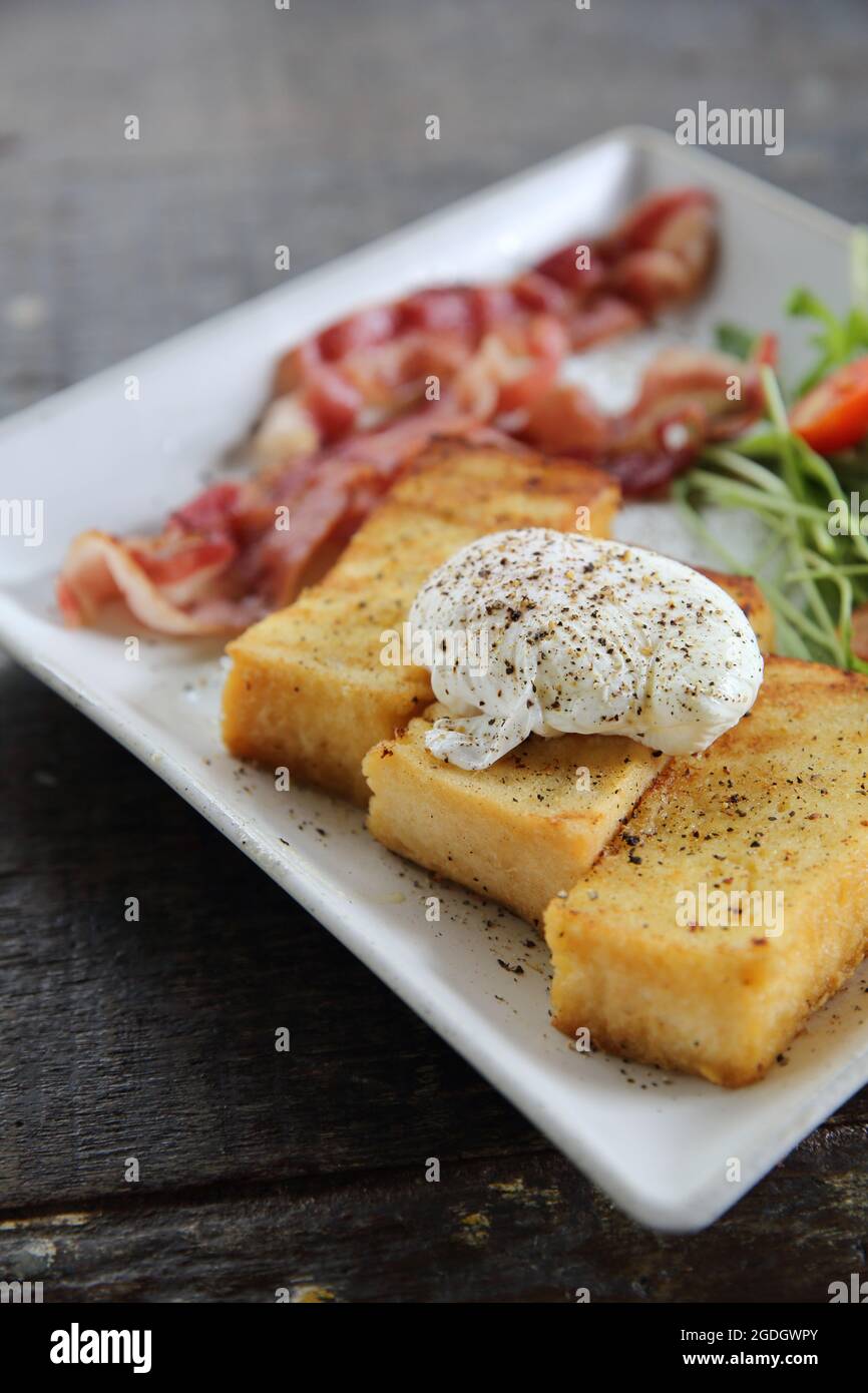 egg benedict with bacon on wood background , breakfast Stock Photo - Alamy