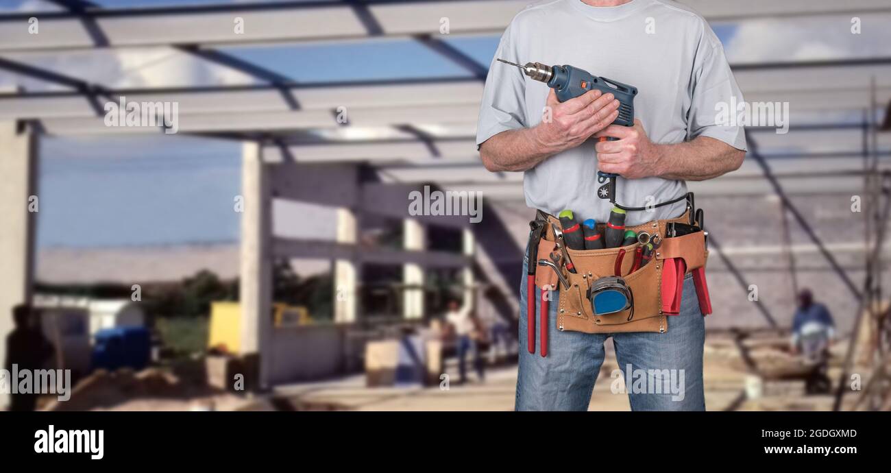 Building worker with tool belt on a construction site background Stock ...