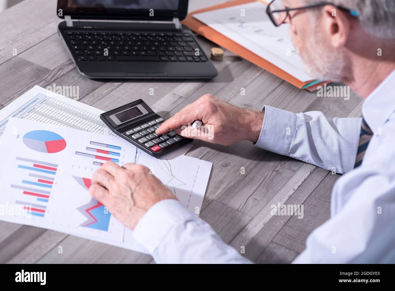 Accountant working on financial documents and using a calculator Stock ...