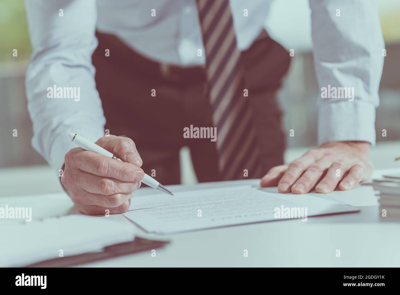 Businessman checking a document in office Stock Photo - Alamy