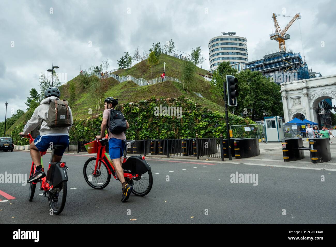 London, UK. 13th Aug, 2021. Cyclists pass Marble Arch Mound ...