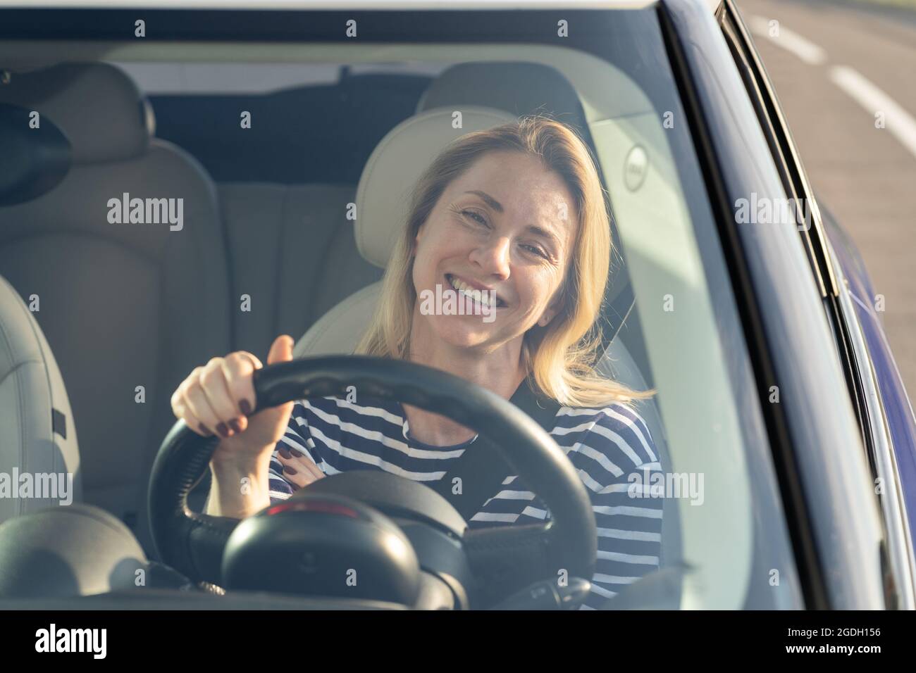 Happy woman enjoy driving new car. Excited female driver in automobile ...