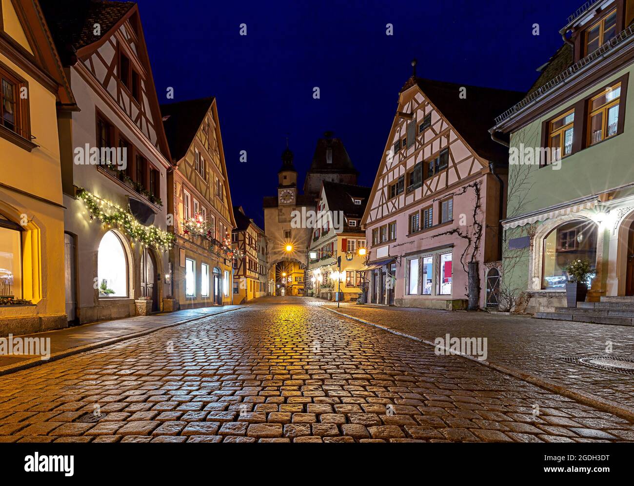 Old traditional medieval street in night illumination. Rothenburg ob ...