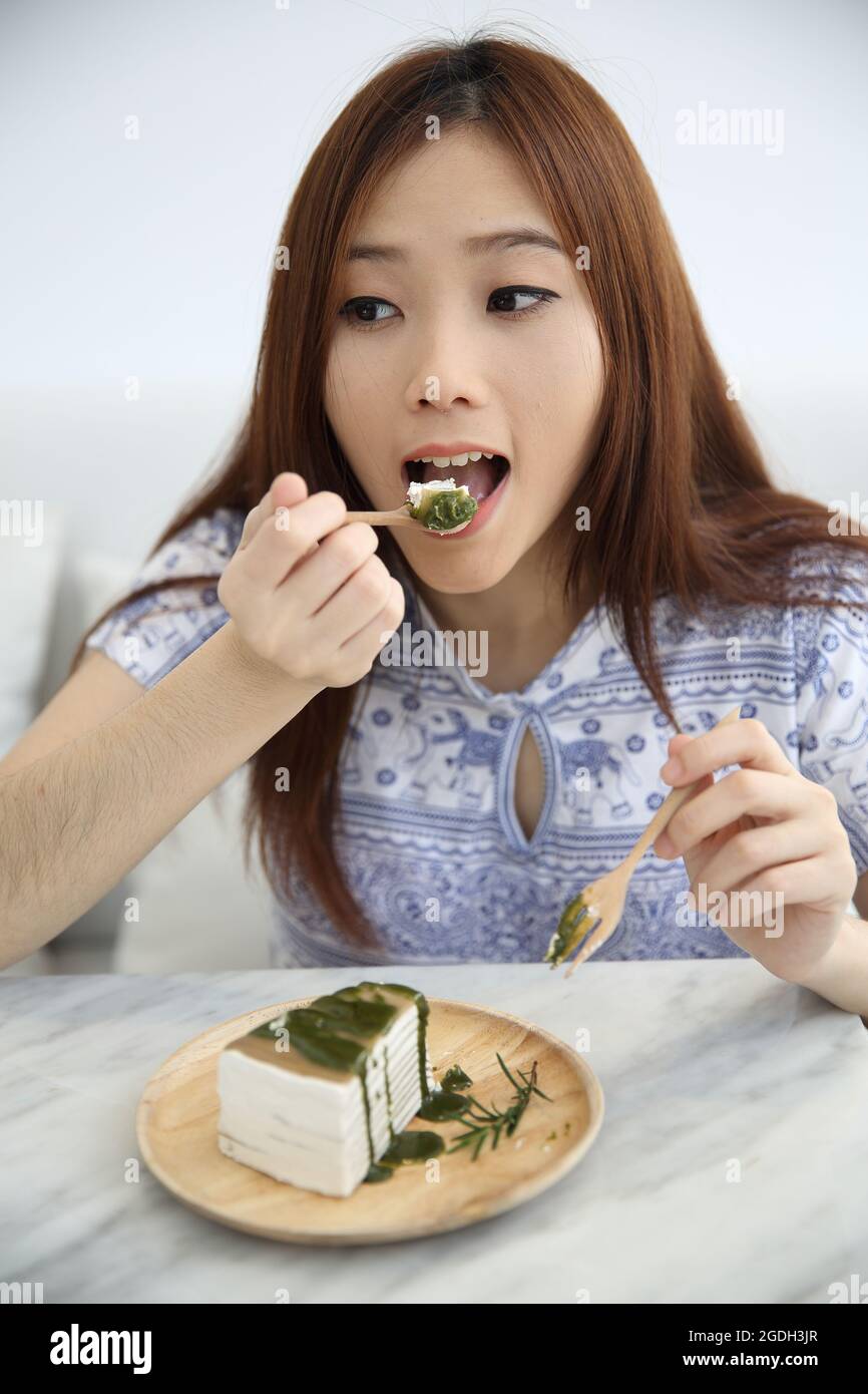 Young Asian Woman eating Green tea crape cake sweet food Stock Photo ...
