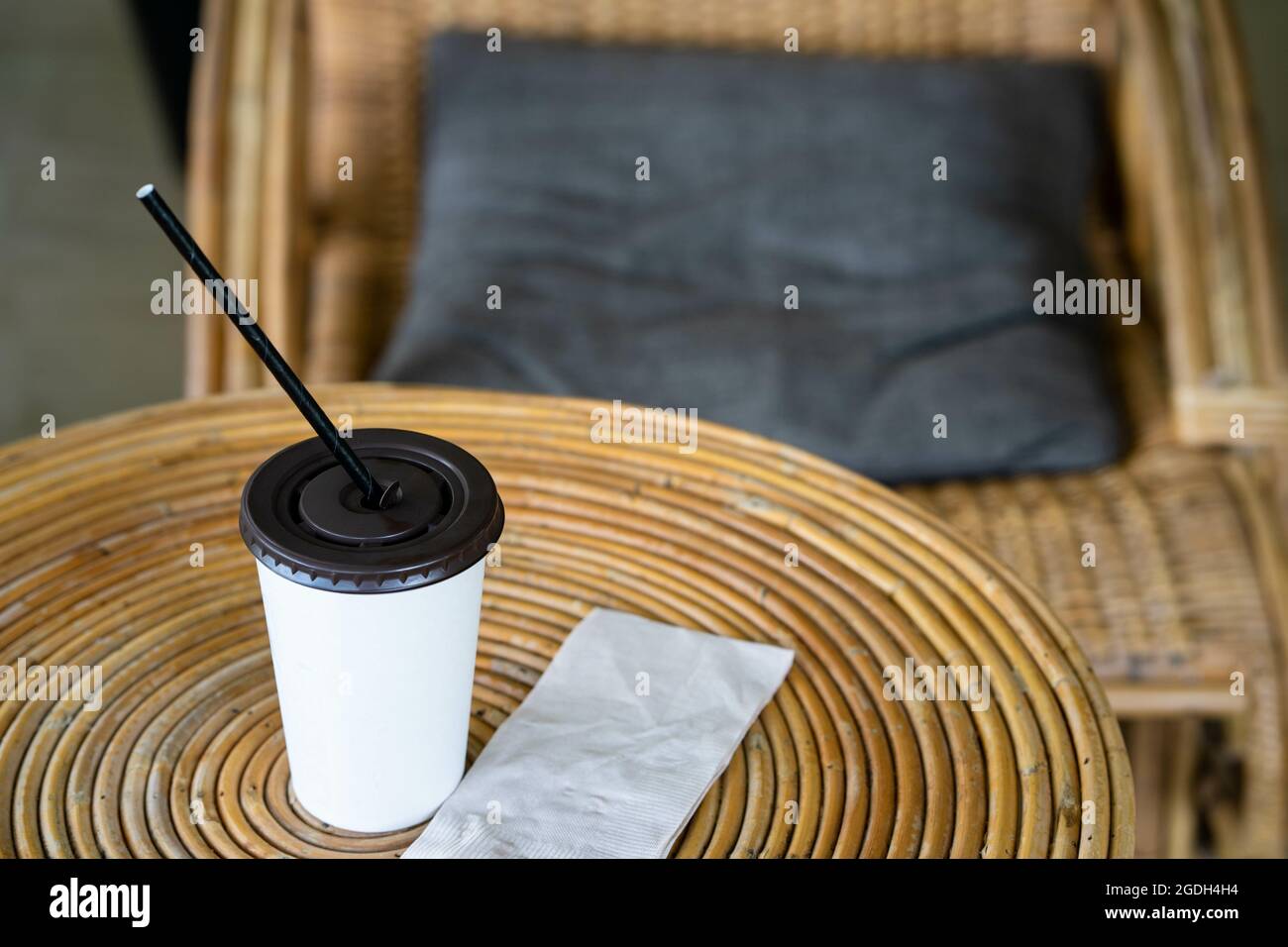 Paper cup of coffee with a straw on a table Stock Photo - Alamy