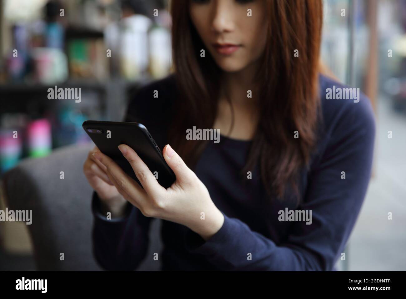 Asian female with hands typing text message Stock Photo - Alamy