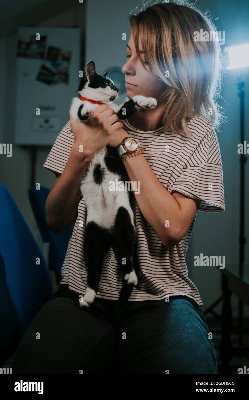 Vertical shot of a young European blonde lady playing with her adorable ...