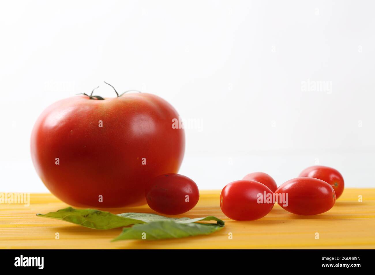 Raw spaghetti noodle with tomatoes and basil isolated in white ...