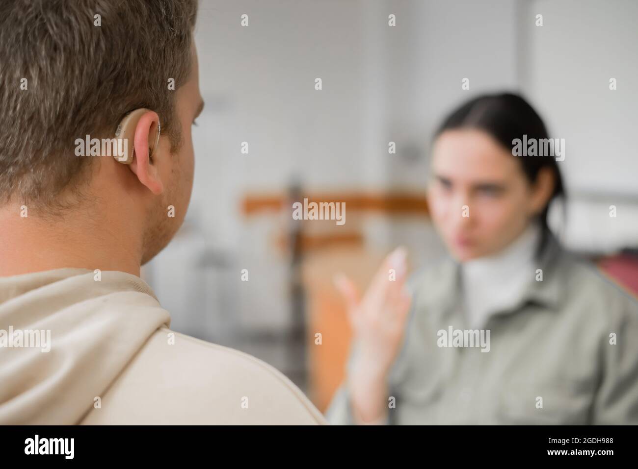 The girl and the guy talk in sign language. Two deaf students chatting ...