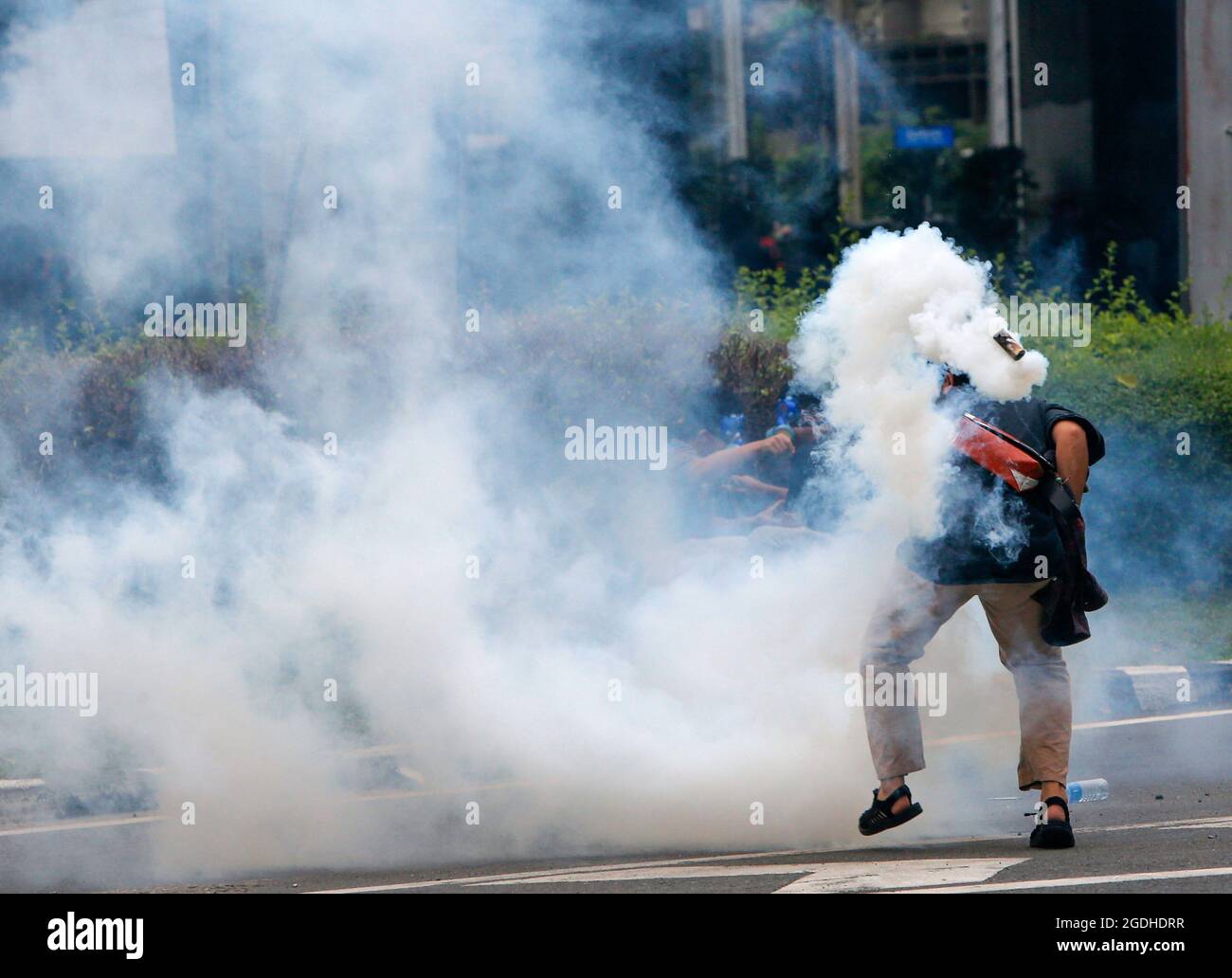 A protester runs amidst teargas smoke during the demonstration. Police ...