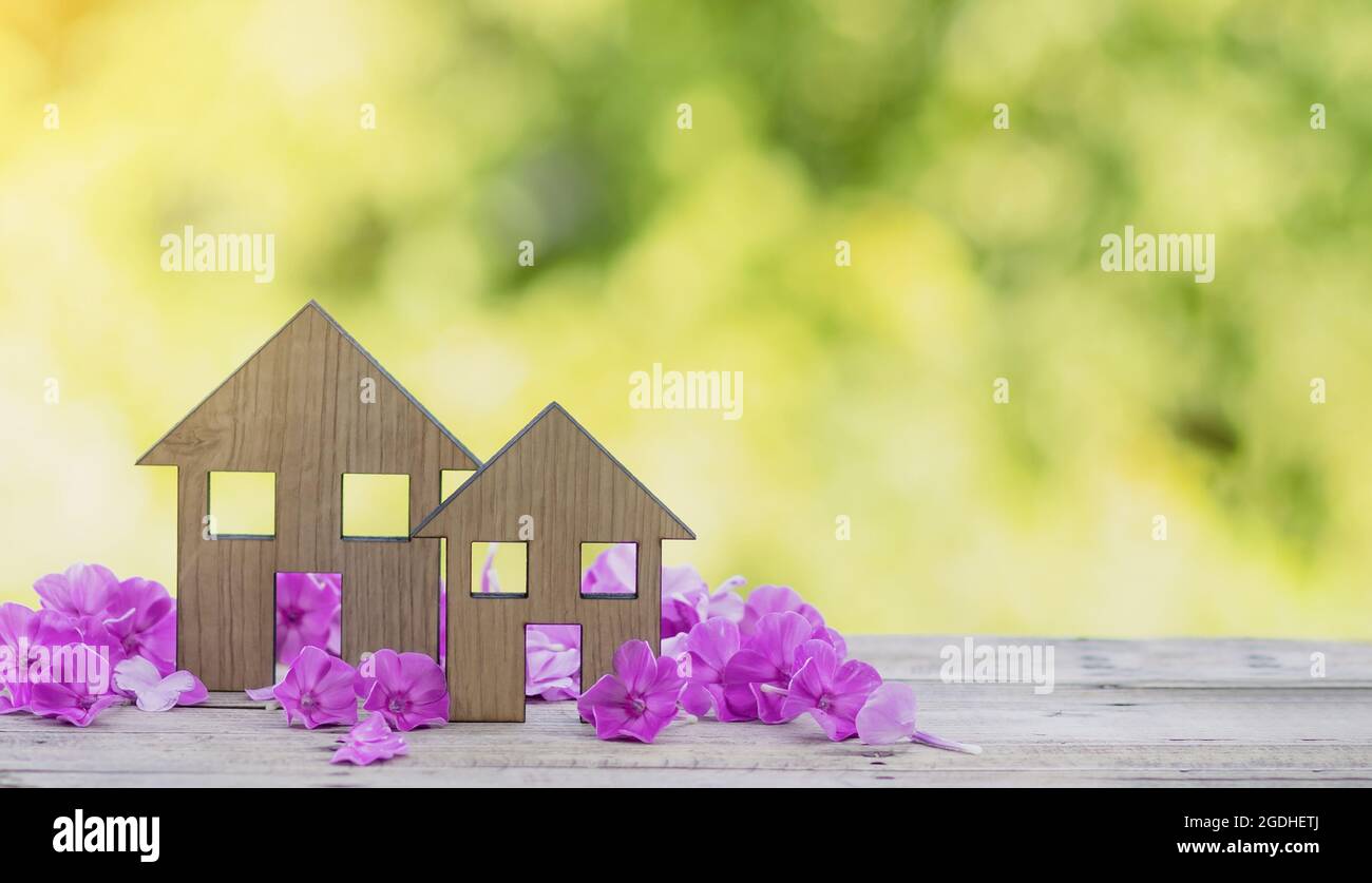Two wooden house figurines on a table with a blurred background Stock ...