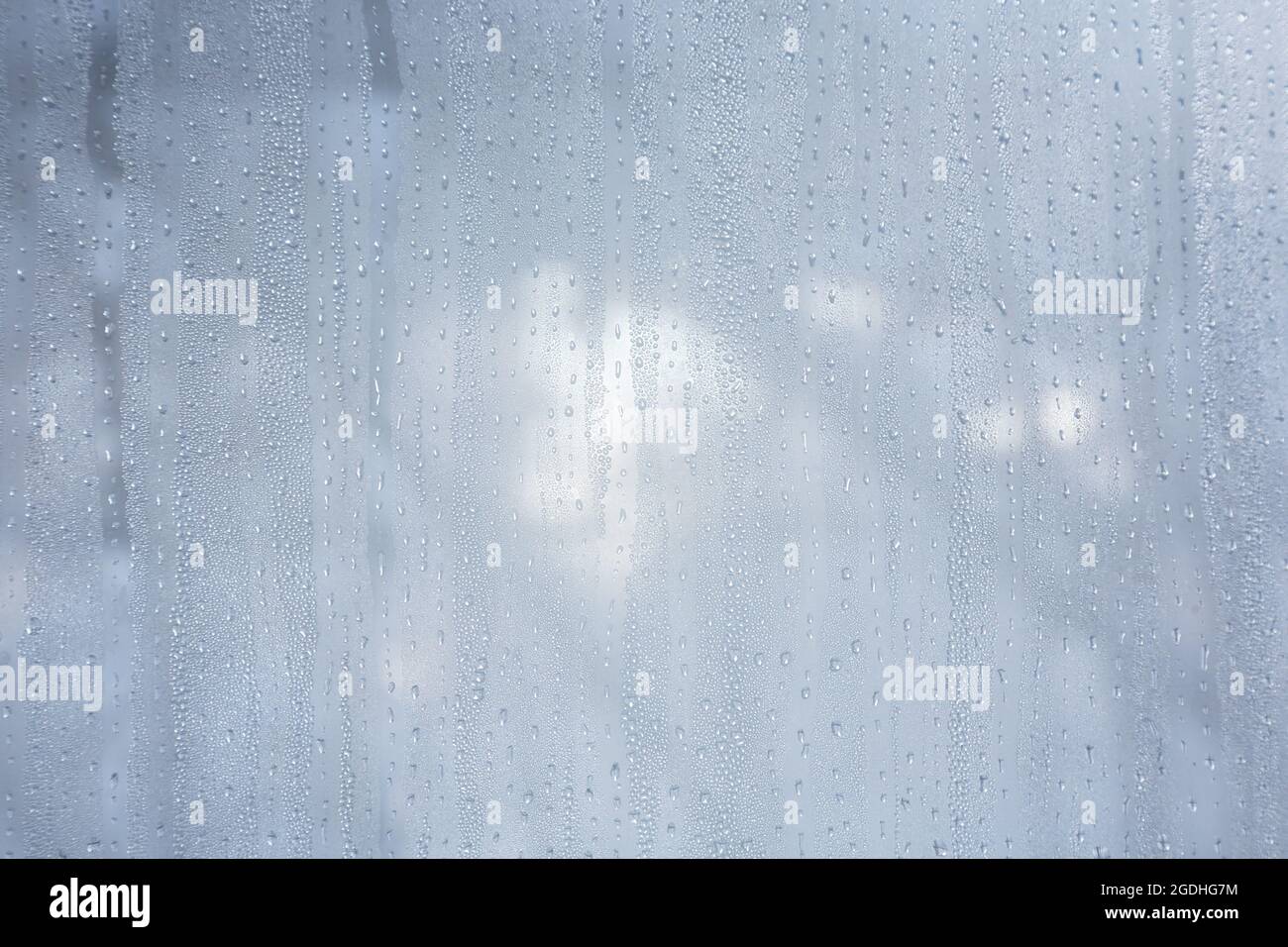 Picture water drops on the fogged glass in the house against the ...