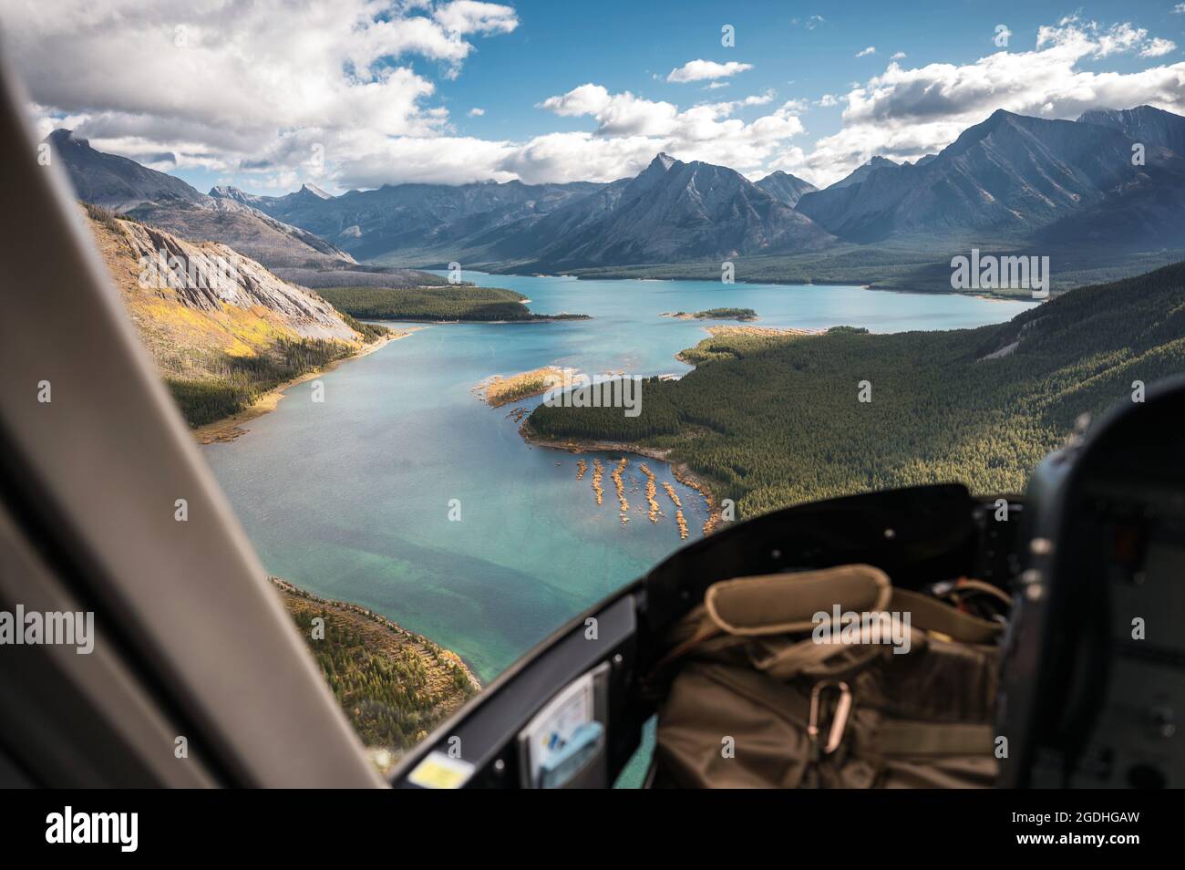Inside of helicopter flying on rocky mountains with turquoise lake and ...