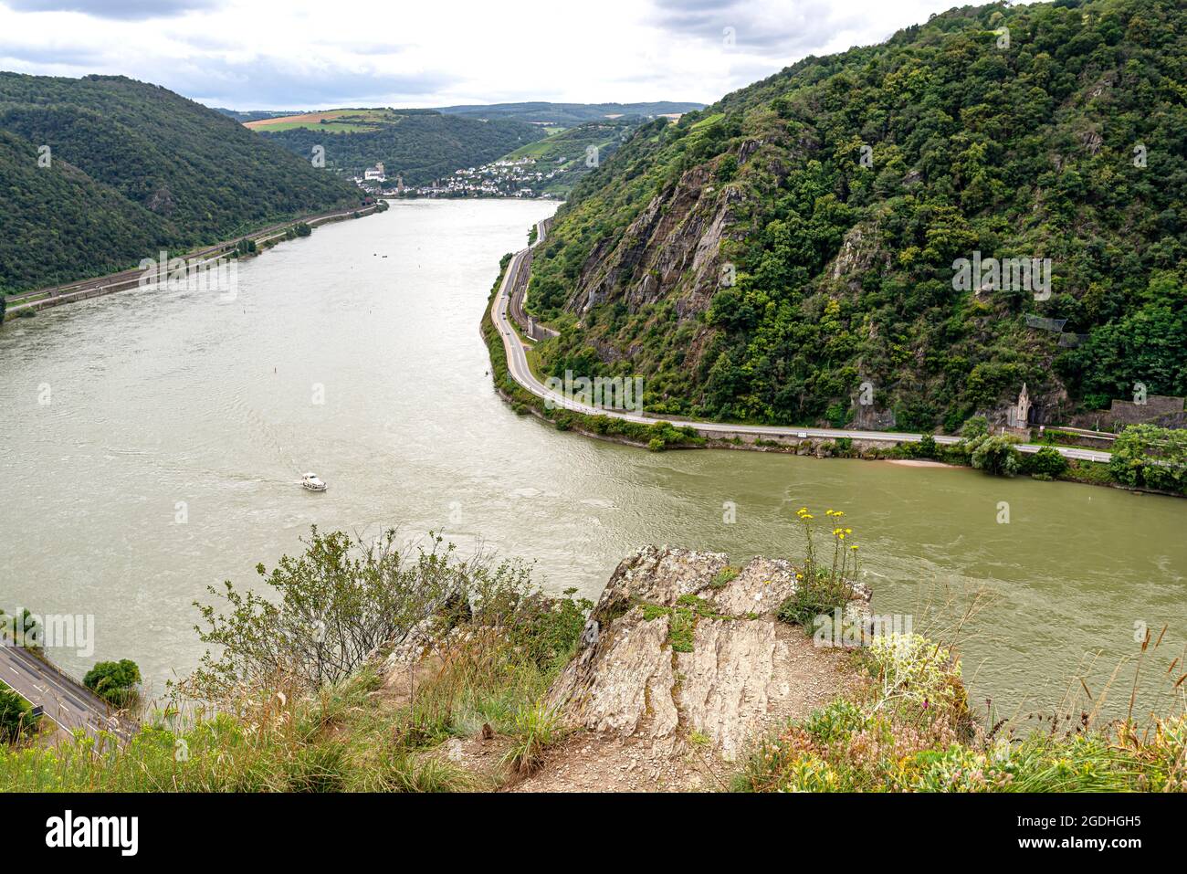The river Rhine in western Germany flows between the hills covered with ...