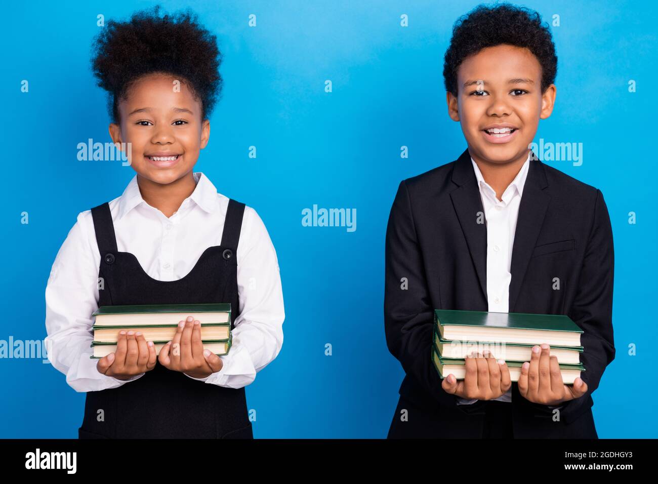 Photo of happy positive dark skin children pupils hold materials books ...