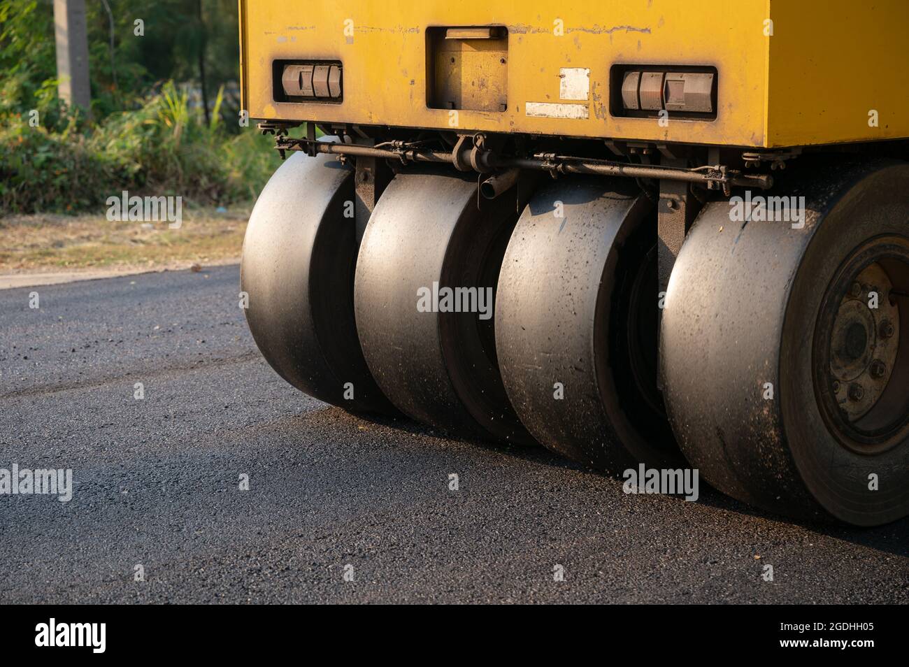 Heavy vibration yellow steamroller or soil compactor working on hot-mix ...