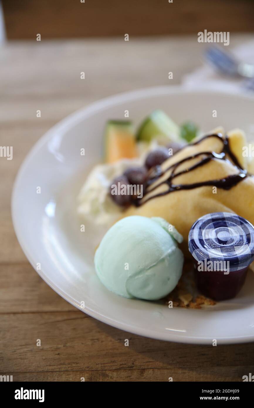 crepe cake with milk ice cream and watermelon melon grapes on wood ...