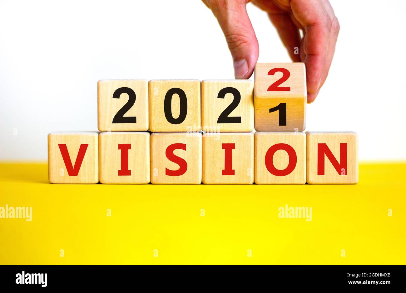 2022 vision new year symbol. Businessman turns a wooden cube and ...