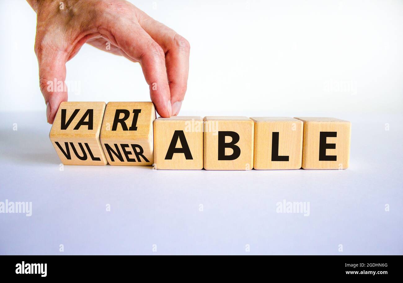 Vulnerable or variable symbol. Businessman turns wooden cubes and ...