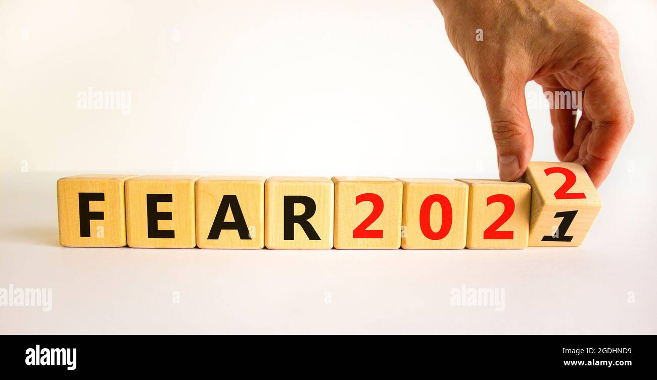 2022 fear new year symbol. Businessman turns a wooden cube and changes words 'Fear 2021' to ...