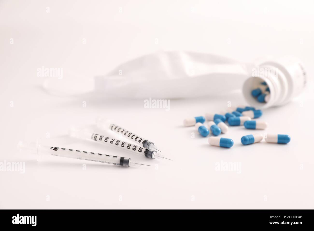 Syringe with pill and mask isolated in white background Stock Photo - Alamy