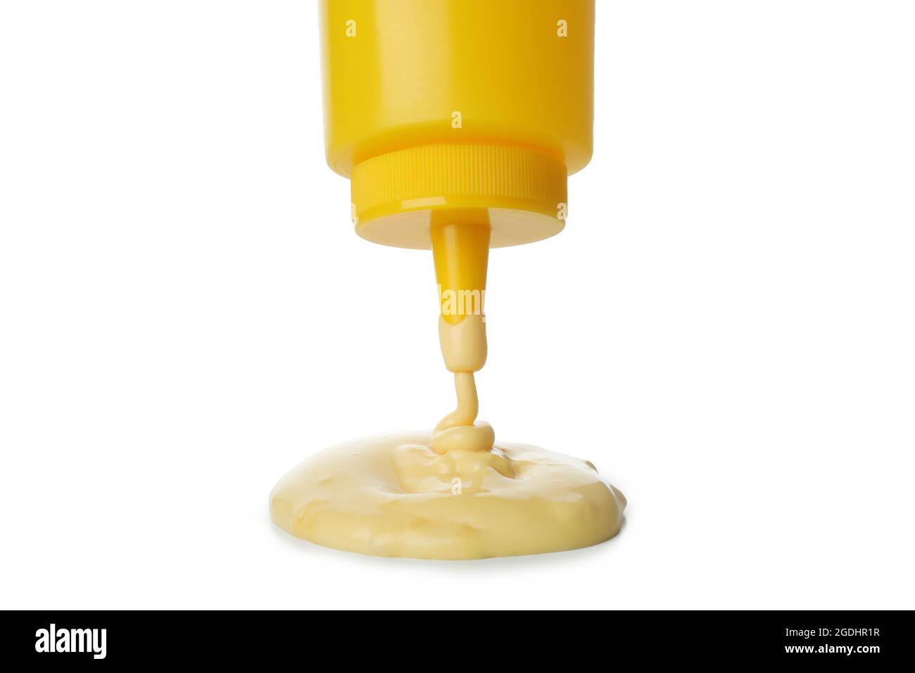 Cheese sauce flows out of the yellow bottle, isolated on white ...