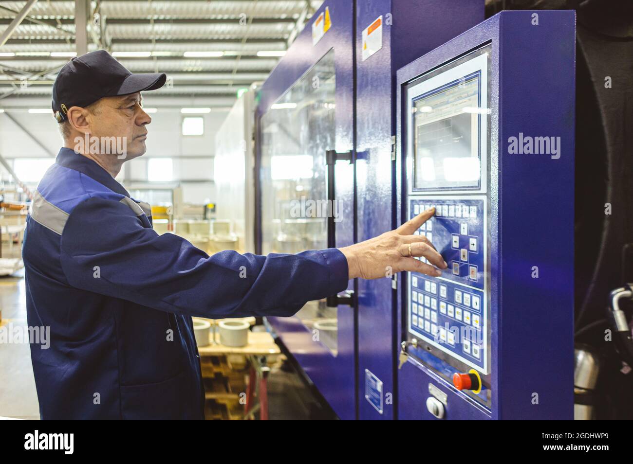A worker presses a button and starts an automatic manufacturing process ...