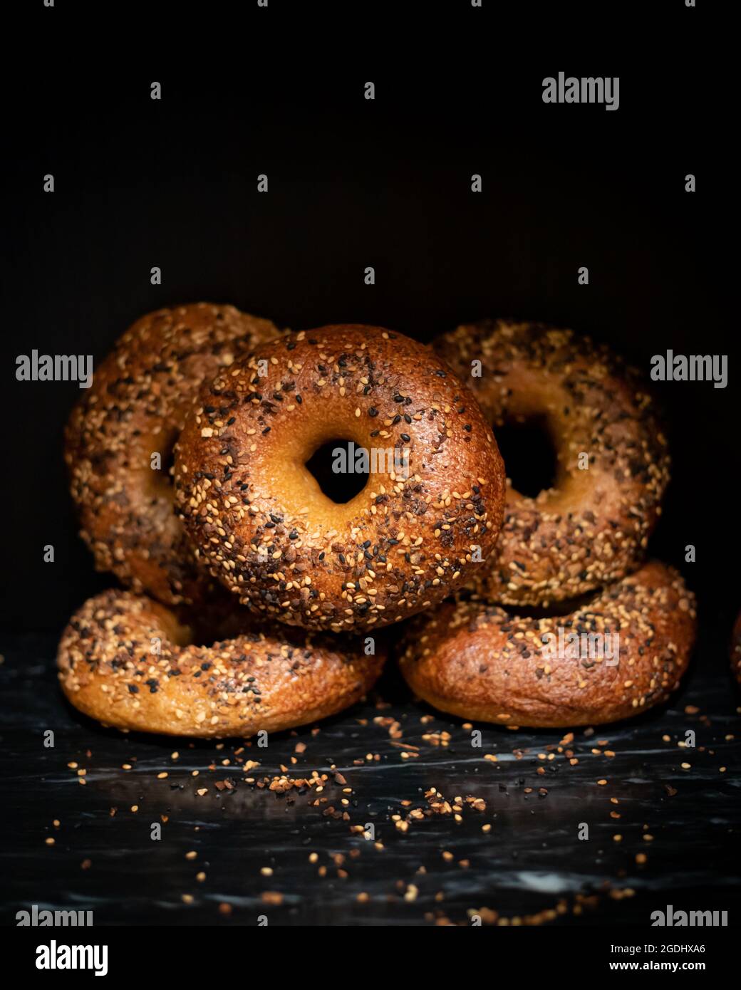 stack of everything bagels on black marble Stock Photo - Alamy