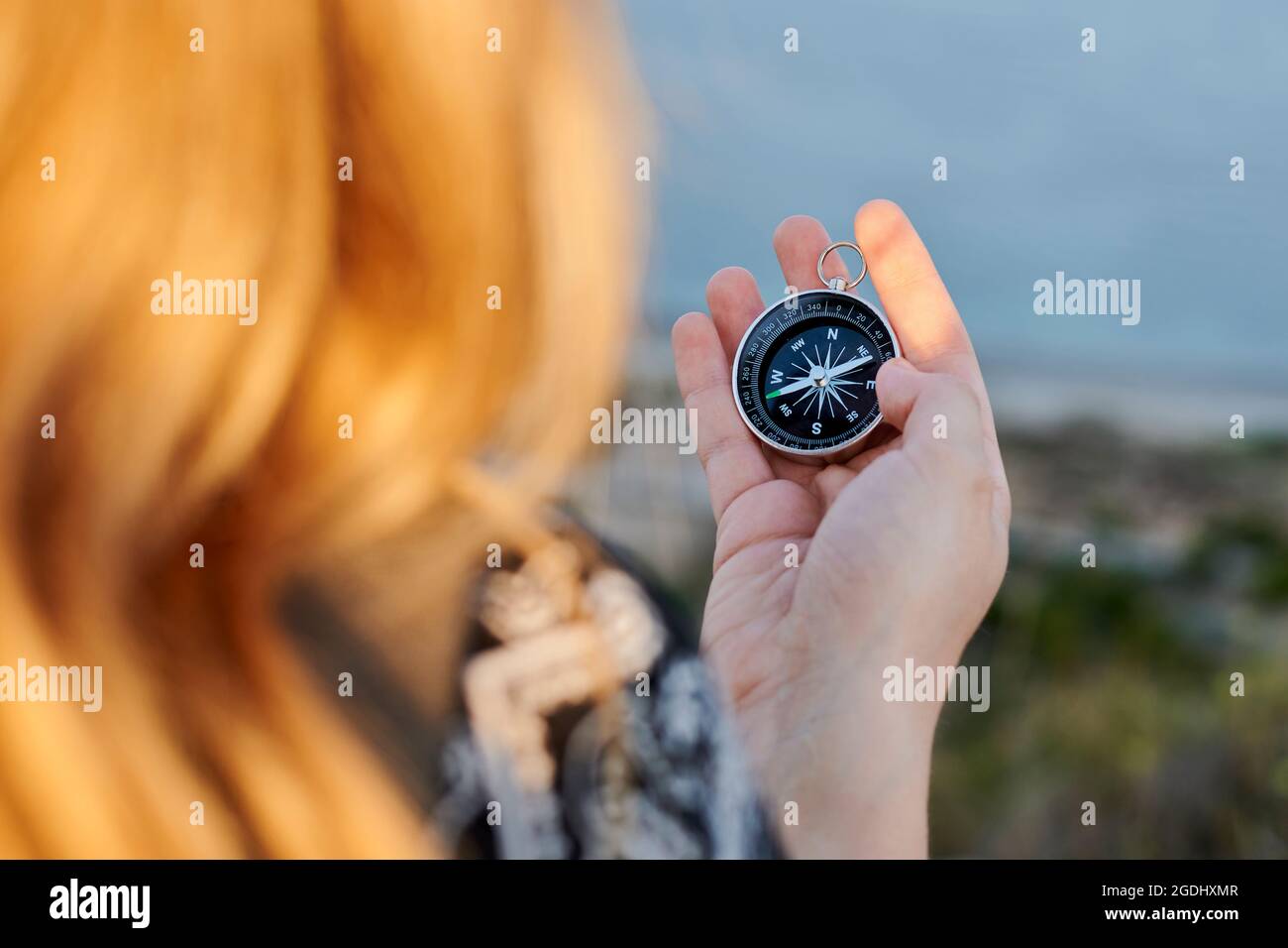 A woman's hands holding a compass Stock Photo - Alamy