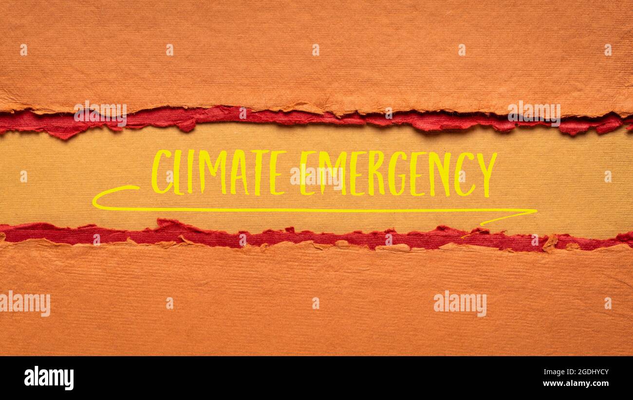 climate emergency word abstract, handwriting on a handmade paper in red ...