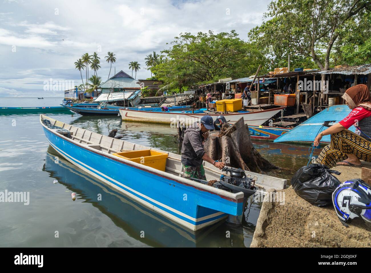 Waisai, Indonesia - Oct 17, 2019: A man checks the engine of his boat ...