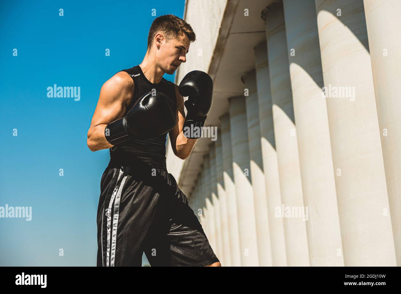 Man exercising and fighting in outside, boxer in gloves. male boxer ...