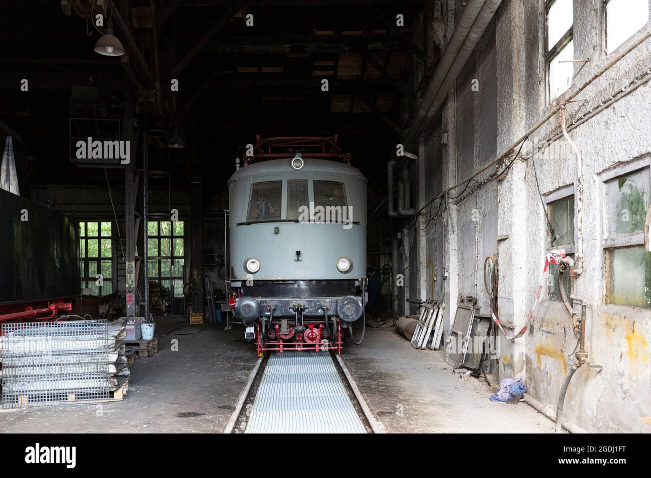 A historical electric railcar stands on a track in the locomotive shed ...