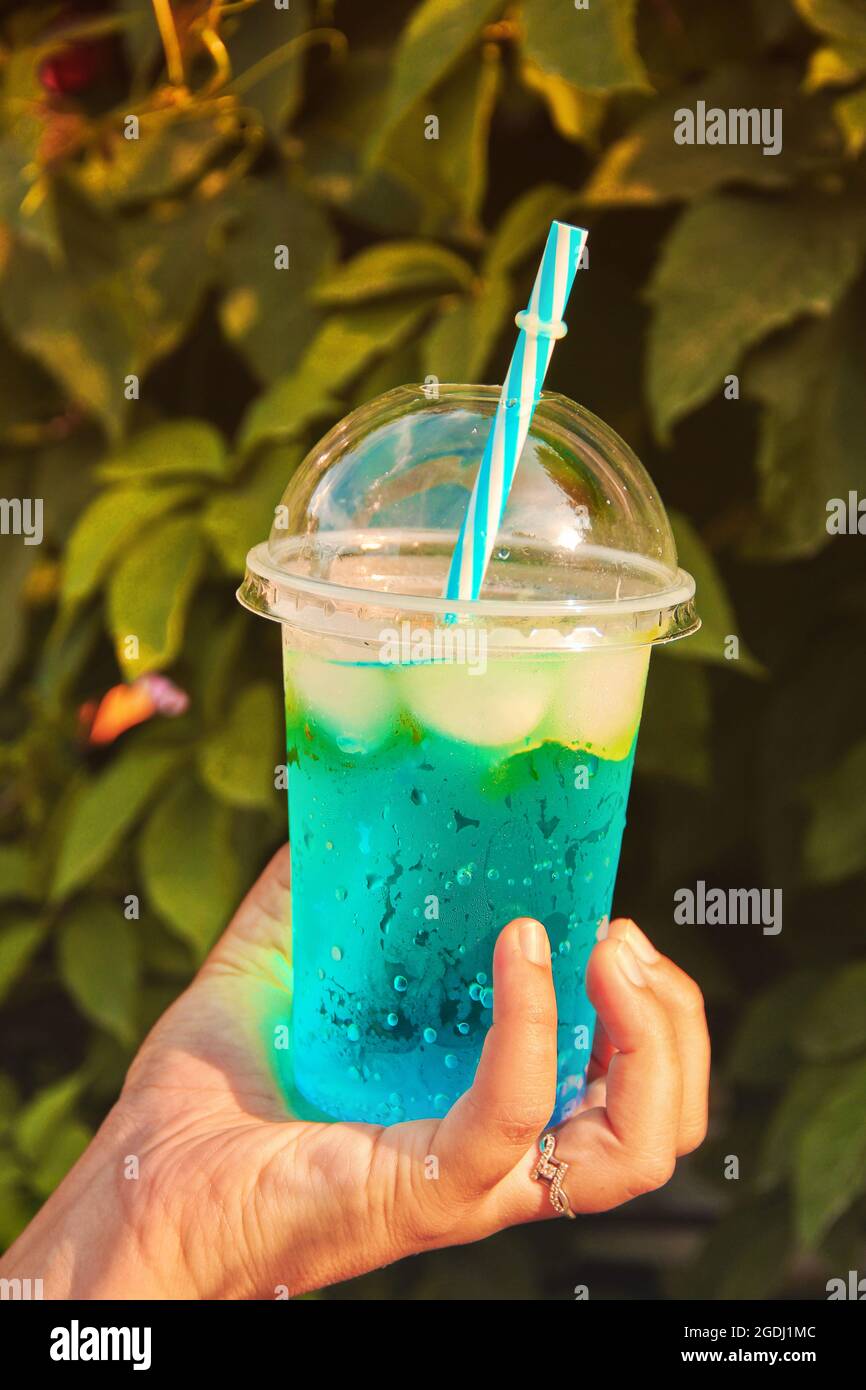 Cocktail in a girl's hand. Juicy drink in the hand Stock Photo - Alamy