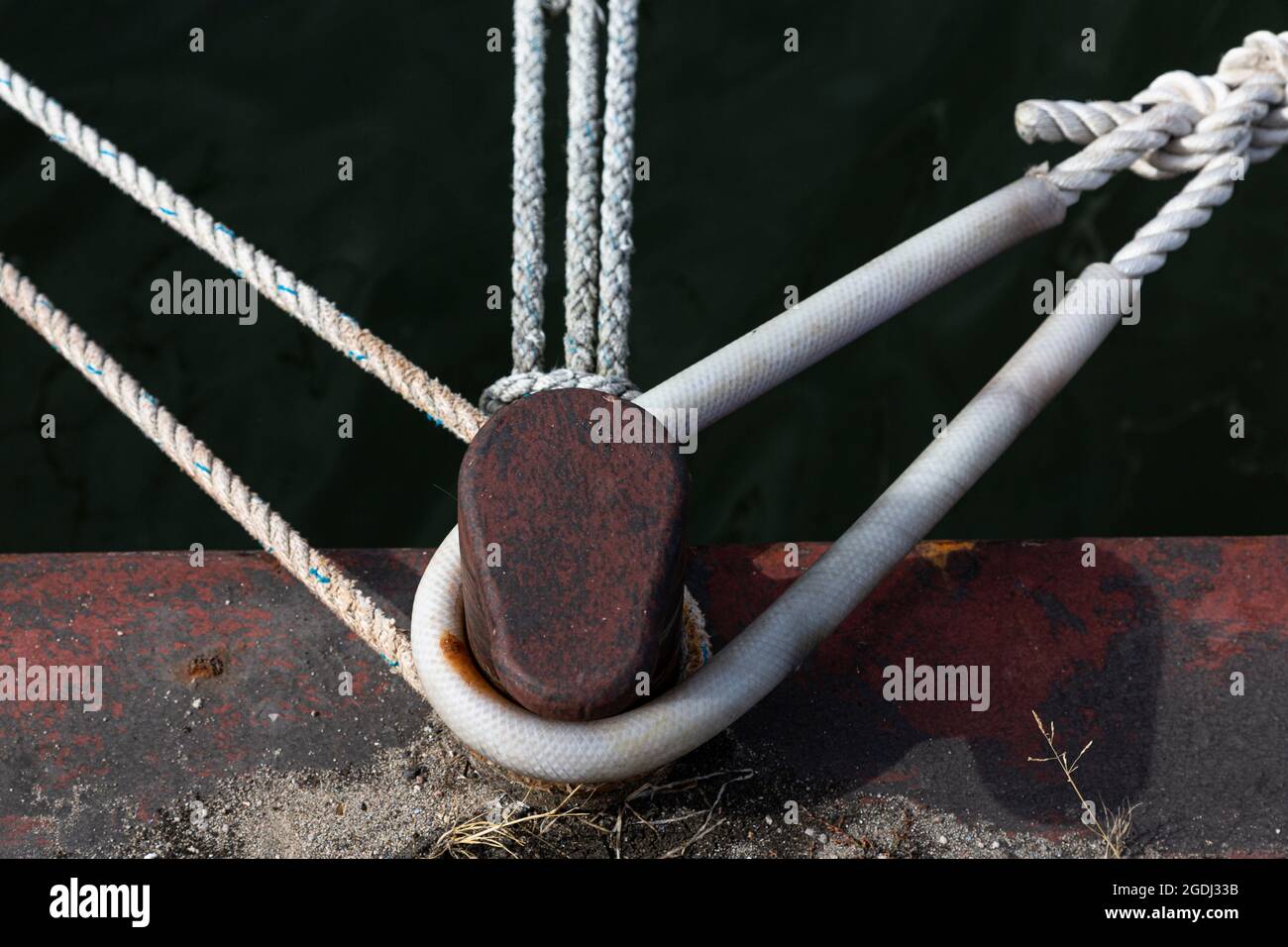 Three different ropes lie around a bollard Stock Photo - Alamy