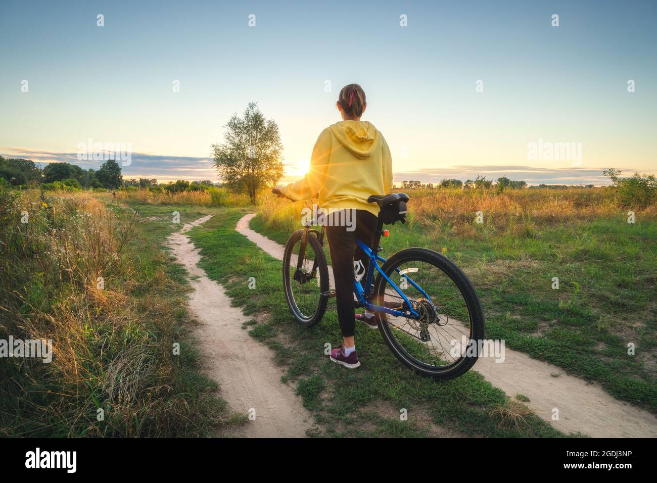 Woman riding a mountain bike in cross country road in summer Stock ...