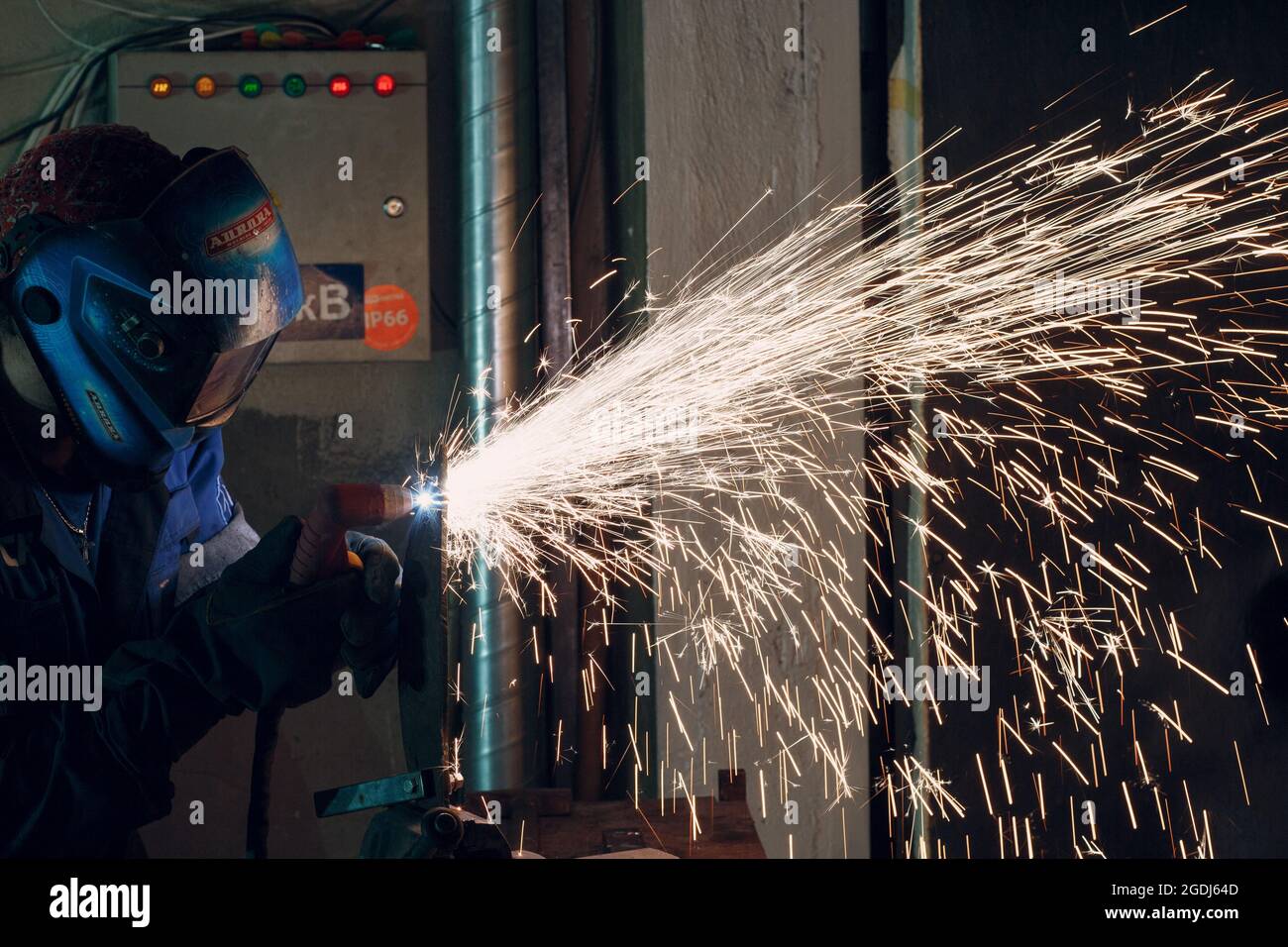 Man in mask cuts metal with plasma cutter. Helmet and spakrs Stock ...