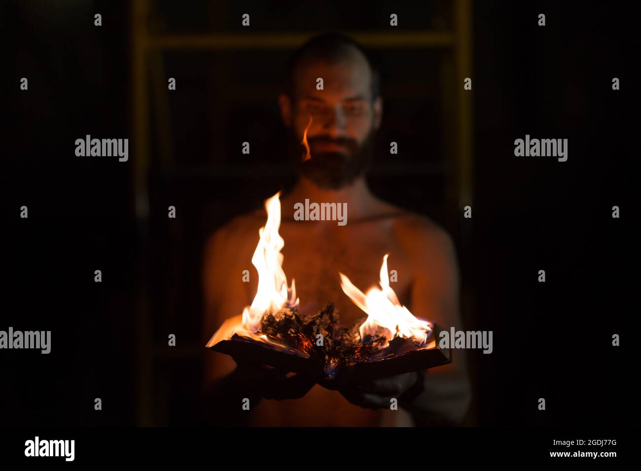 Man hold burning book in his hands Stock Photo - Alamy