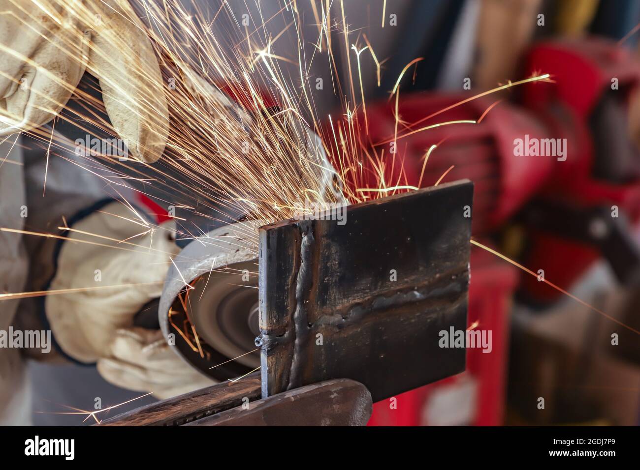 Sparks from the act of grinding a steel plate made by a worker who can ...