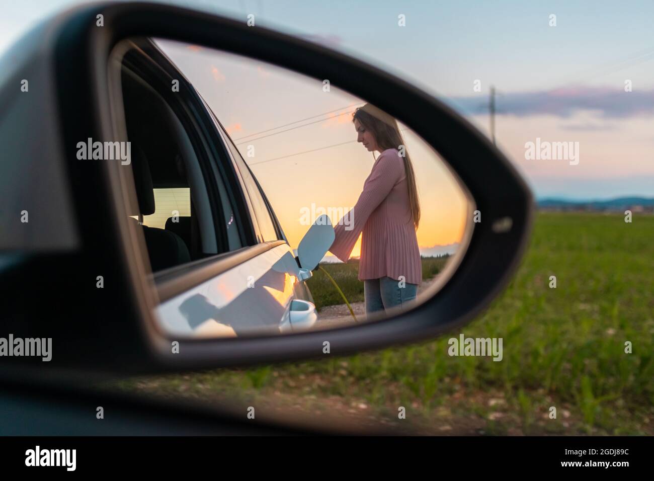 Rear mirror with a reflection of the female silhouette charging an ...