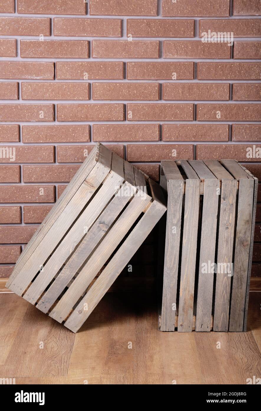 Rectangular wooden boxes on the floor in front of brick wall Stock ...