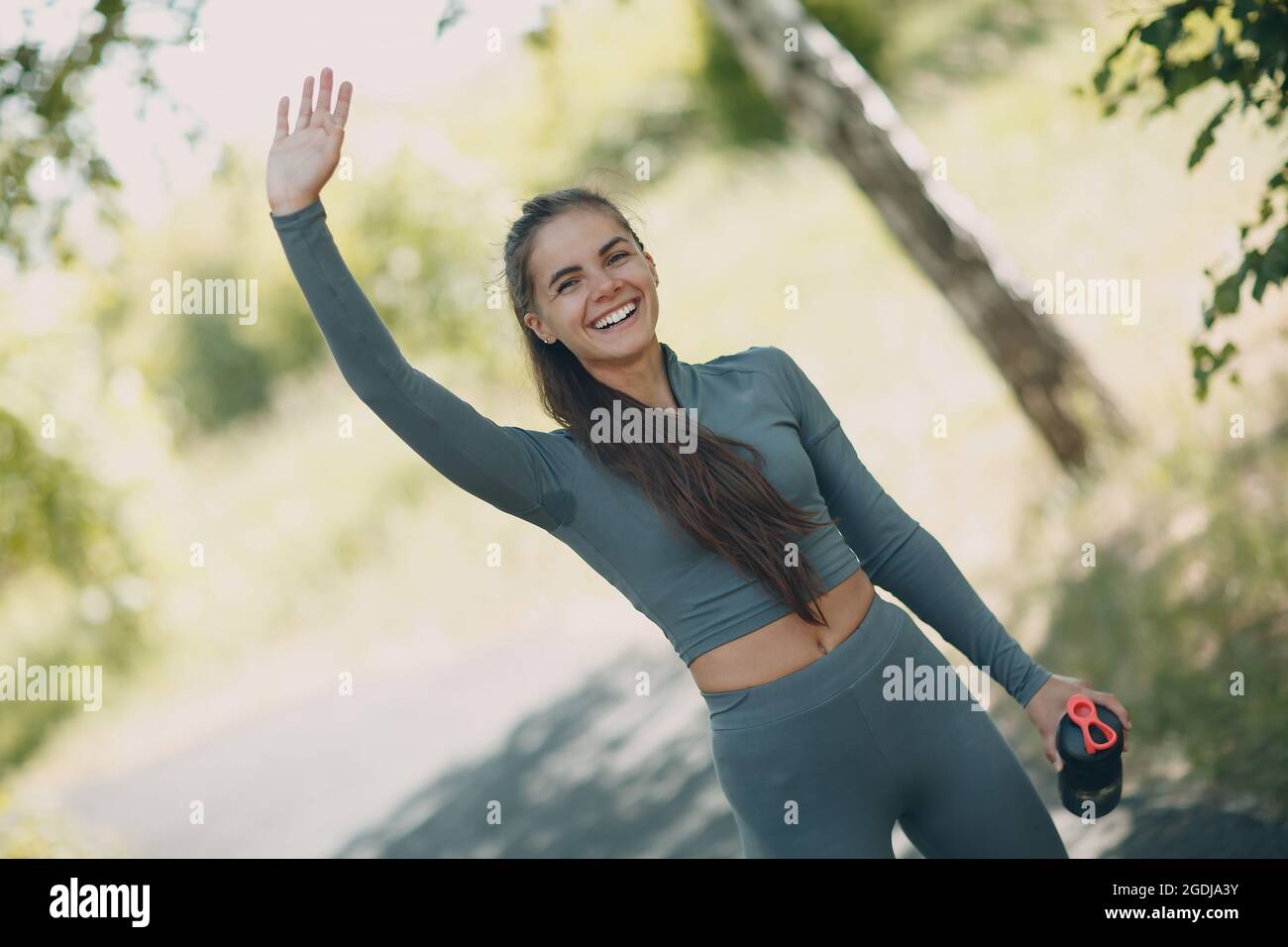 Tired runner woman jogger drinking bottled water after jogging Stock ...