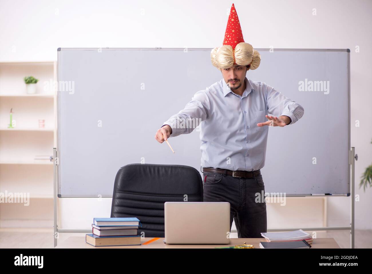 Funny young teacher magician in the classroom Stock Photo - Alamy
