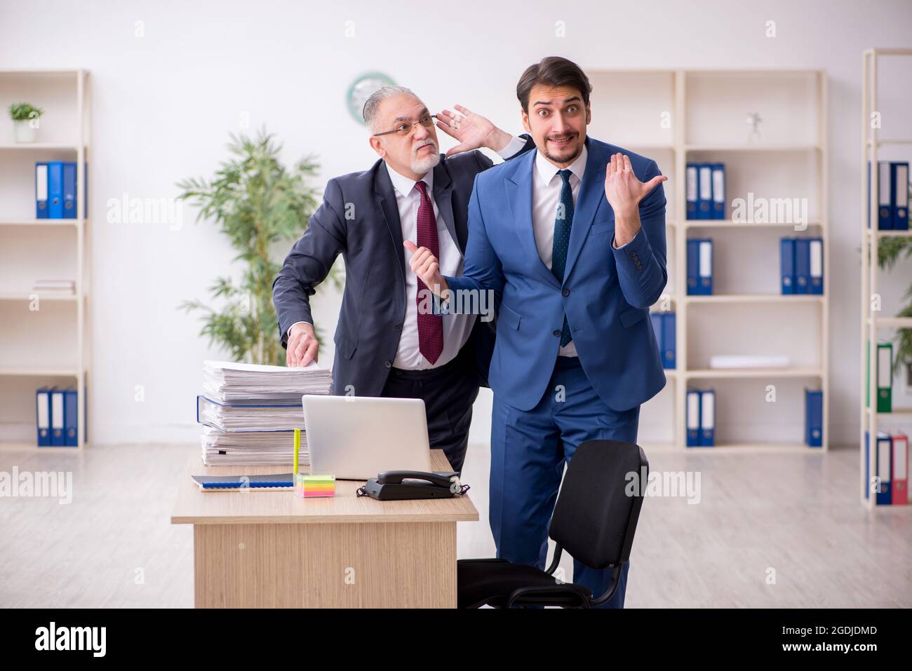 Old boss and young employee in bullying concept Stock Photo - Alamy