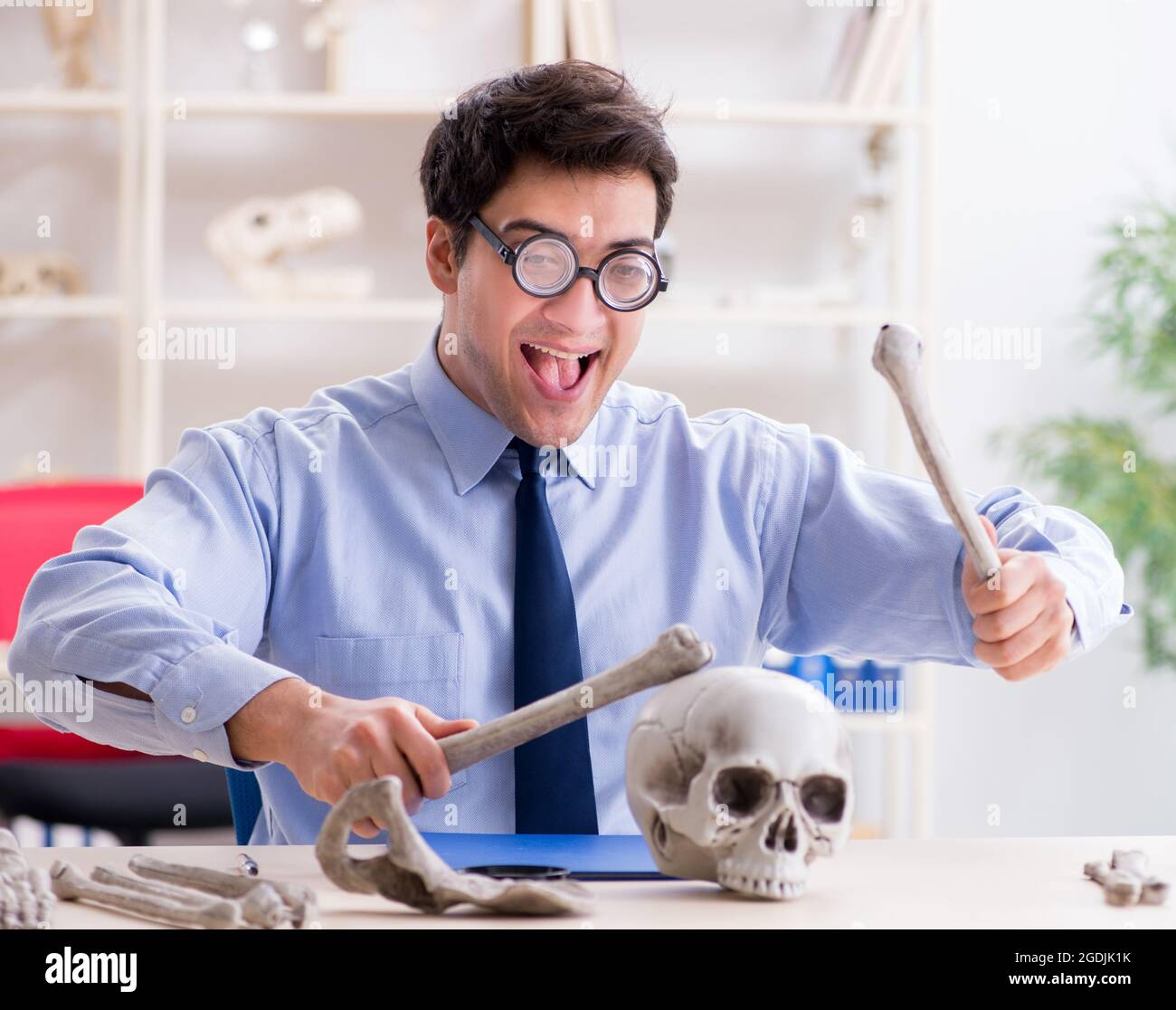 The funny crazy professor studying human skeleton Stock Photo - Alamy