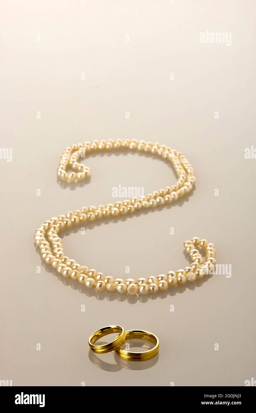 question mark made of a pearl necklace and wedding rings, marriage yes ...