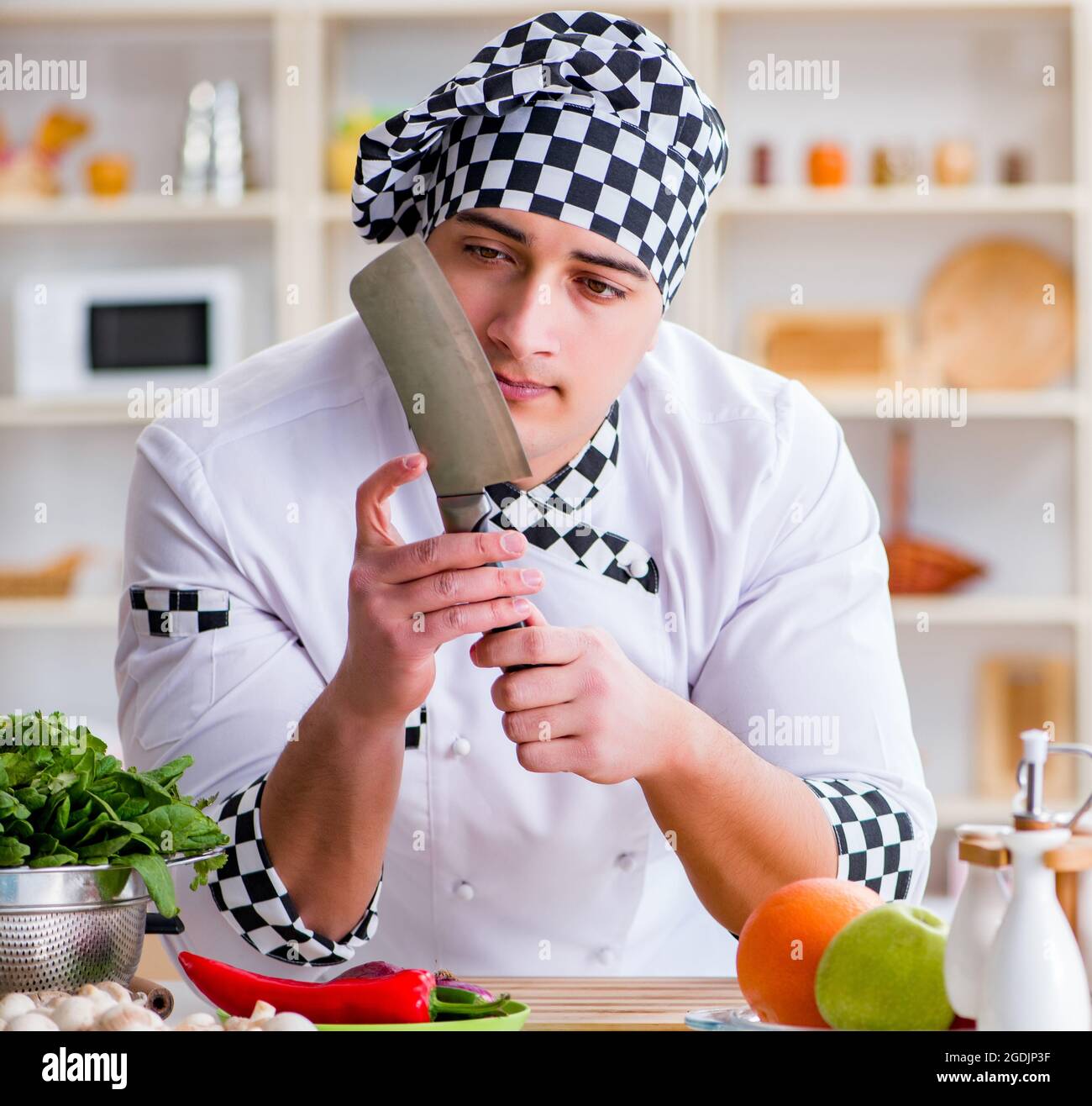 The young male cook working in the kitchen Stock Photo - Alamy