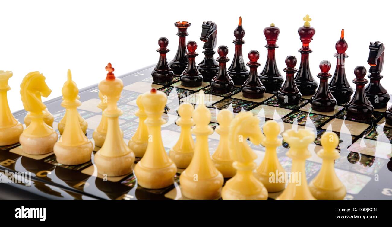 Natural amber different chess pieces figures standing on pearl board in ...