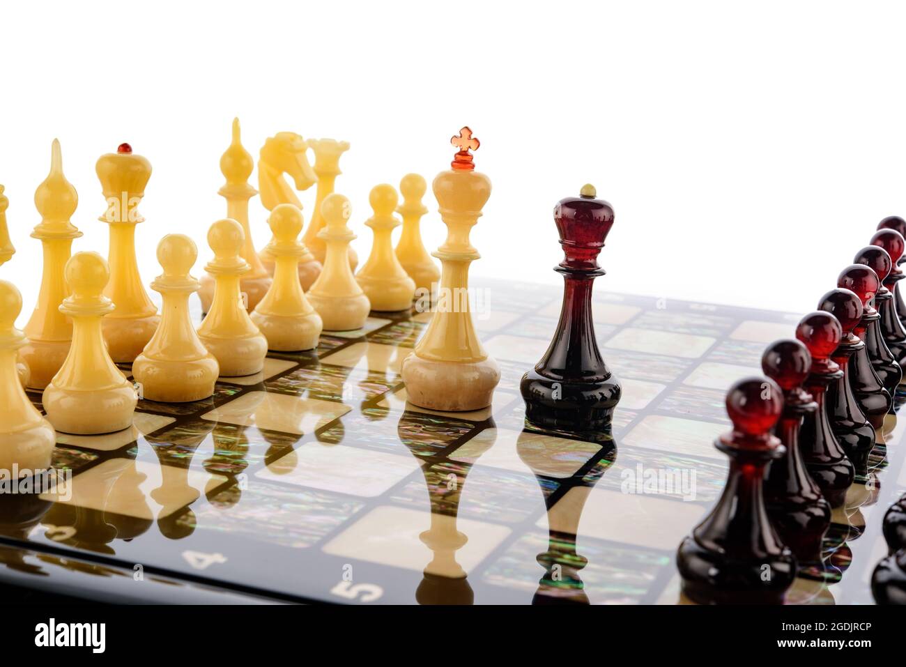 Natural amber different chess pieces figures standing on pearl board in ...