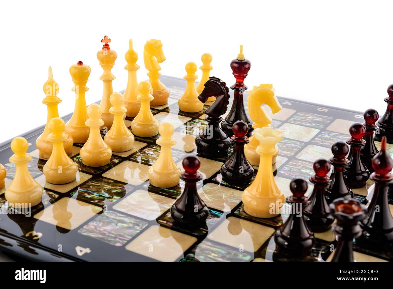 Natural amber different chess pieces figures standing on pearl board in ...